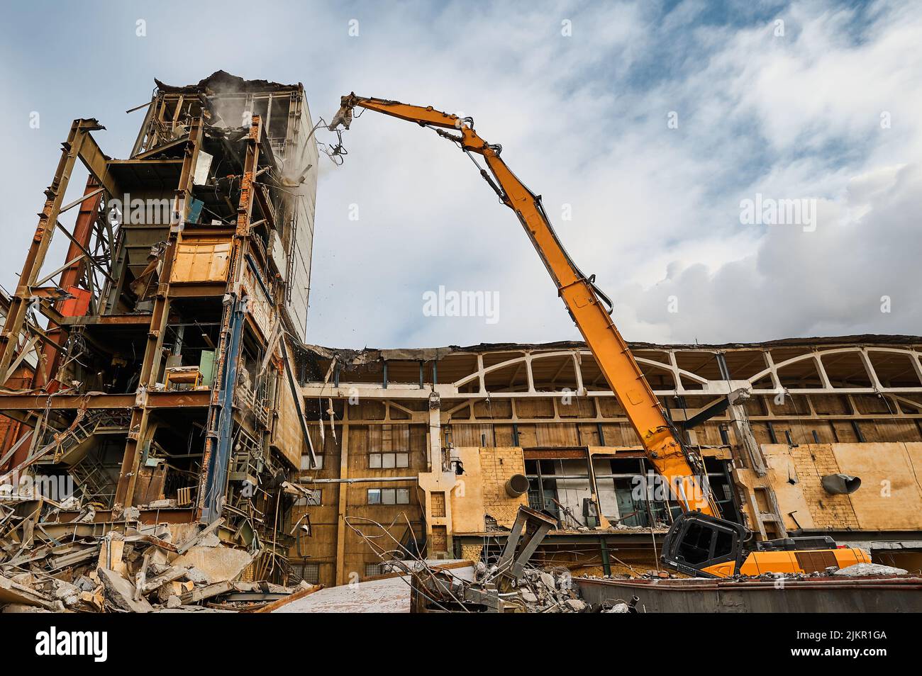 Destroyer excavator with large manipulator near factory Stock Photo - Alamy