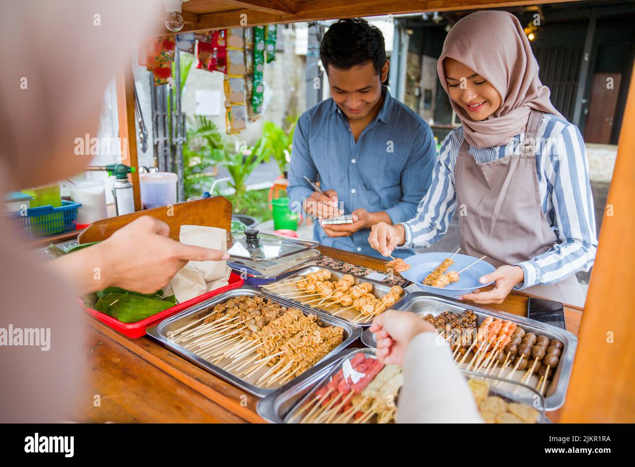 muslim couple ordering food to break fasting in ramadan Stock Photo - Alamy