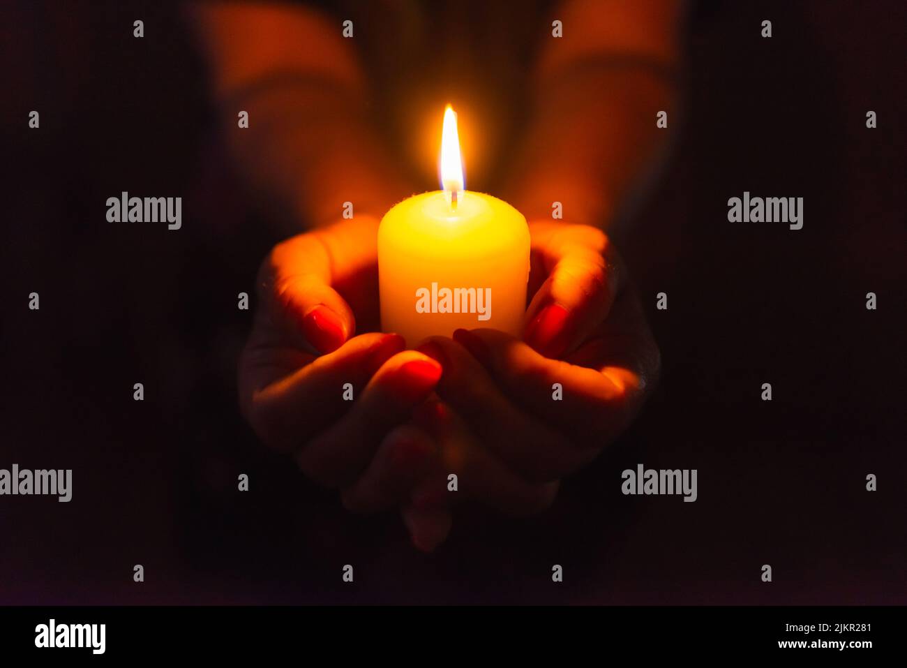 Candle in female hands on black dark background.Prayers candle in hands ...