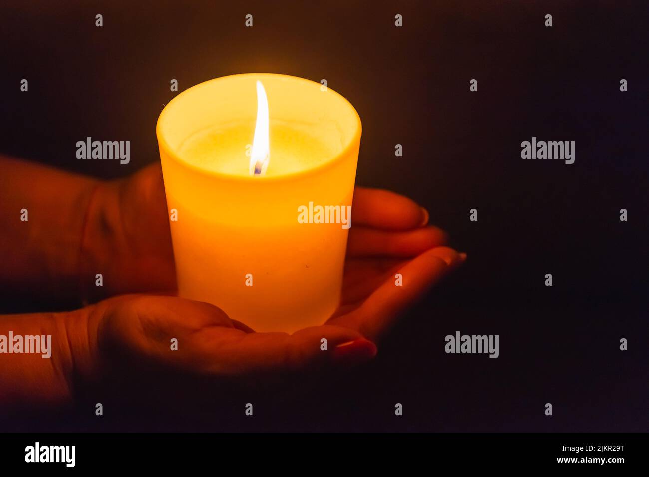 Candle in female hands on black dark background.Prayers candle in hands ...