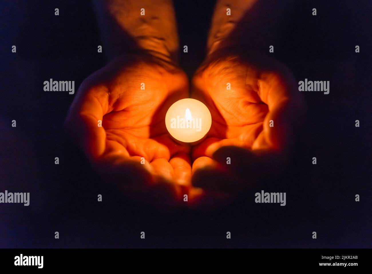 Burning candle in a mans hand religion concept.Candle in hands on a ...