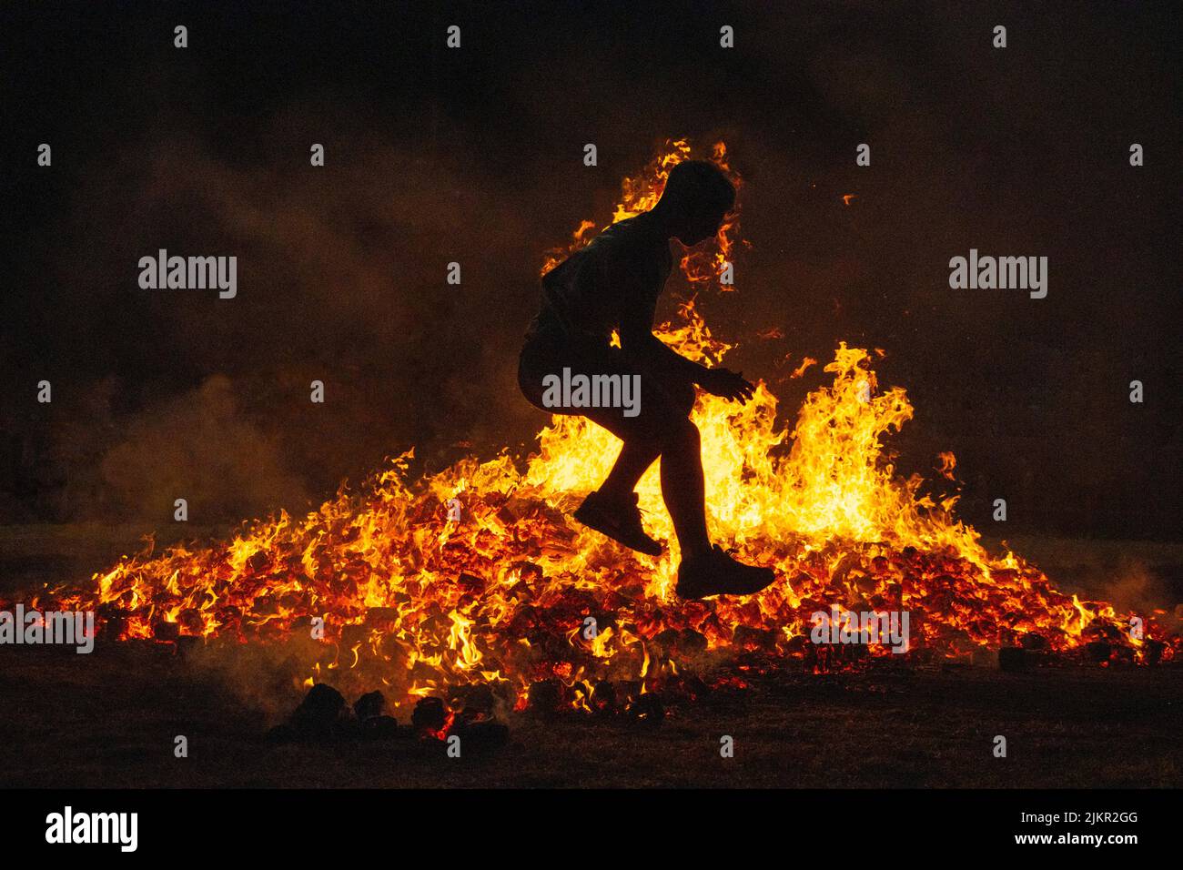 Summer solstice celebration jumping into the fire. Burning flames ...