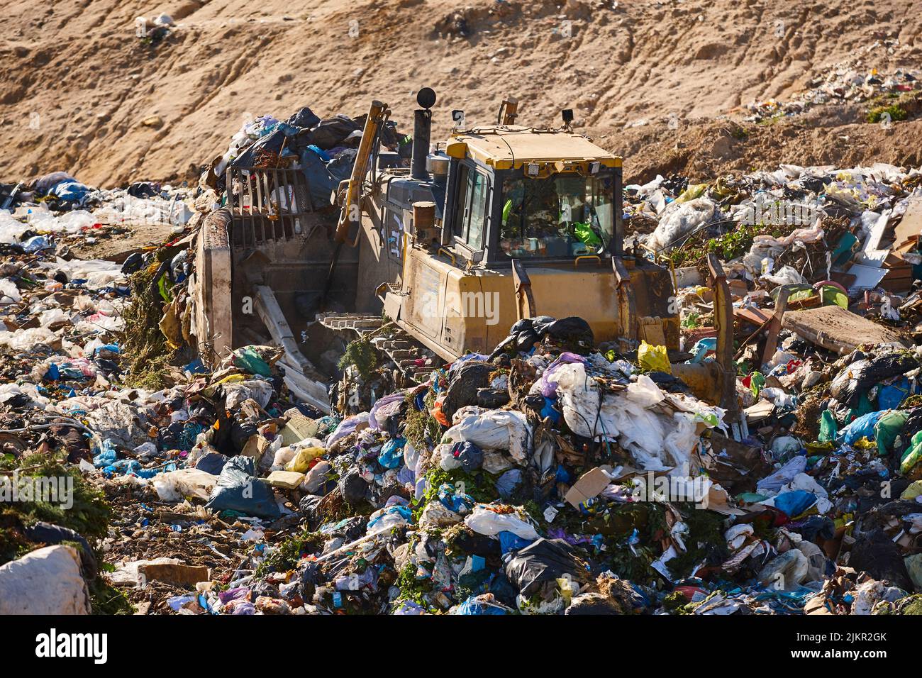 Heavy machinery shredding garbage in an open air landfill. Waste Stock ...