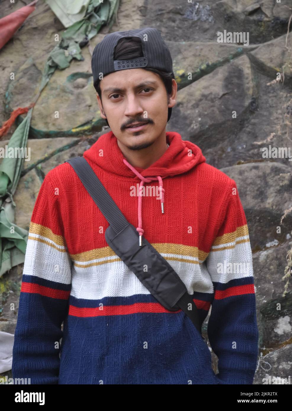 Front view of a young guy with wearing cap backwards, looking at camera ...