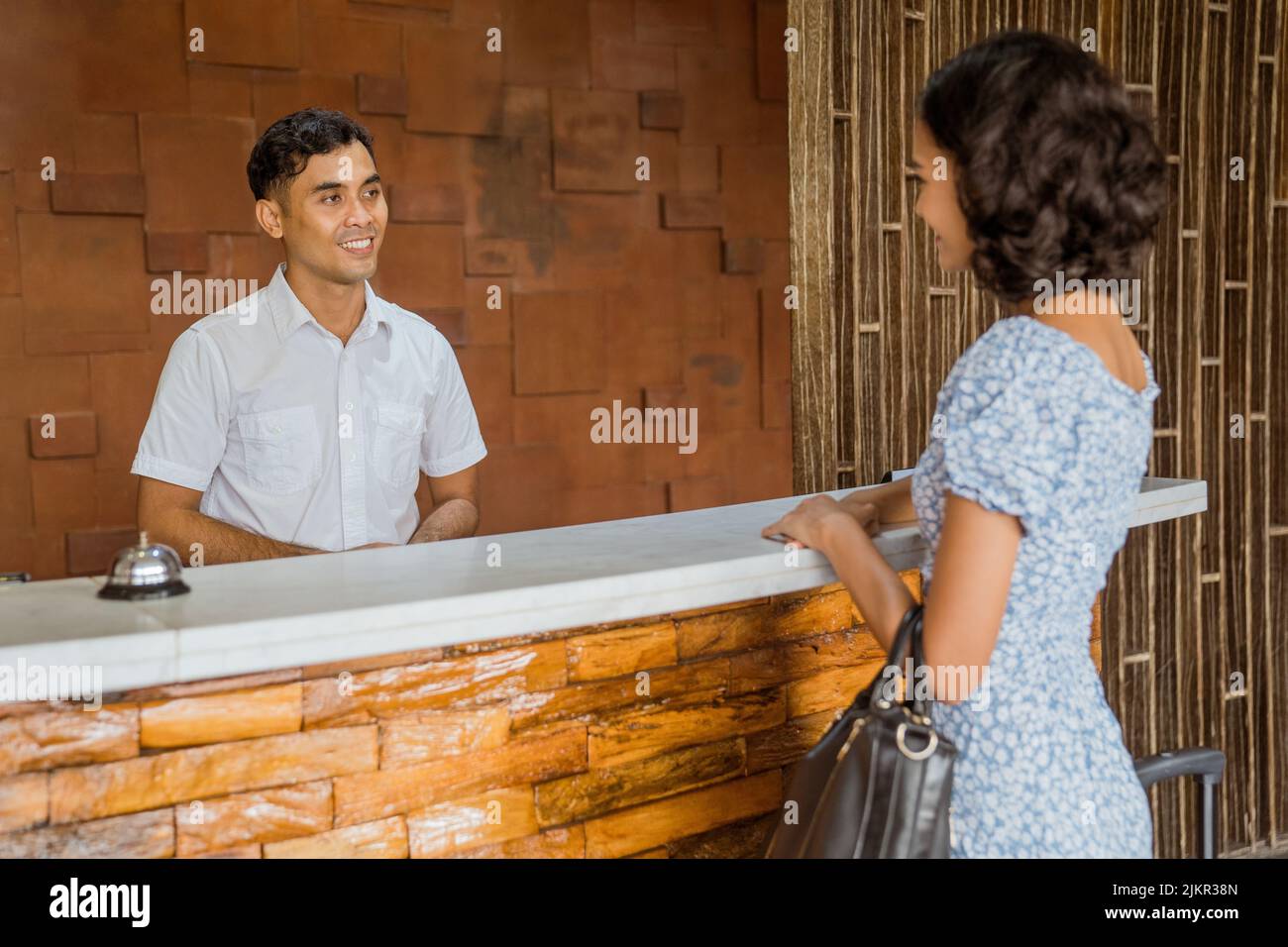The receptionist smiles welcoming female guests to the hotel lobby ...
