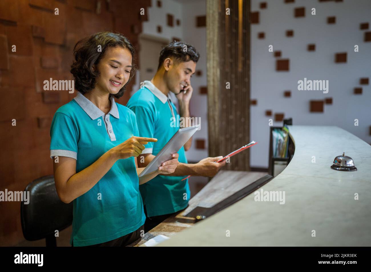 female receptionist using pad at the reception desk Stock Photo - Alamy