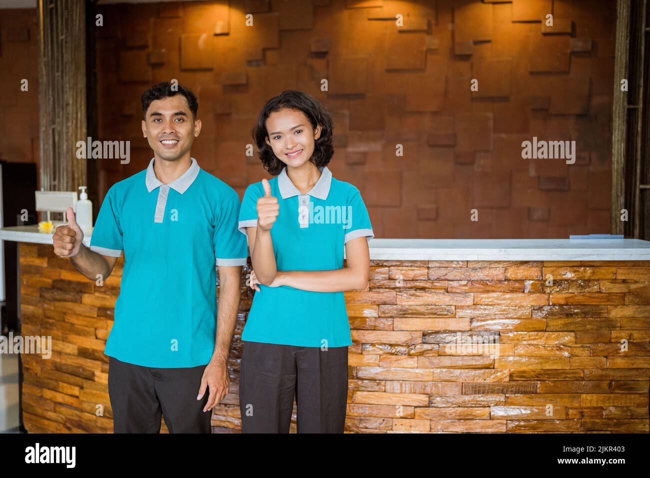two janitors wearing turquoise uniforms standing with thumbs up Stock ...