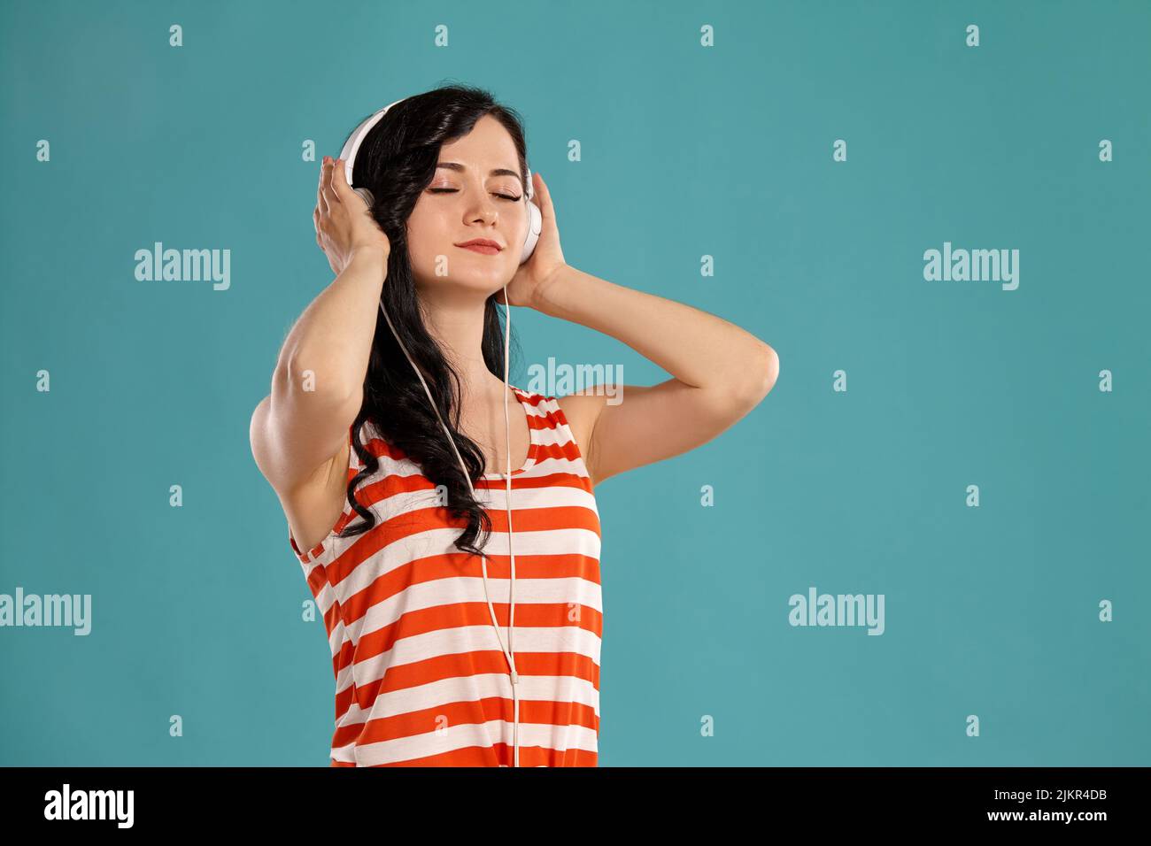 Studio photo of a gorgeous girl teenager posing over a blue background ...