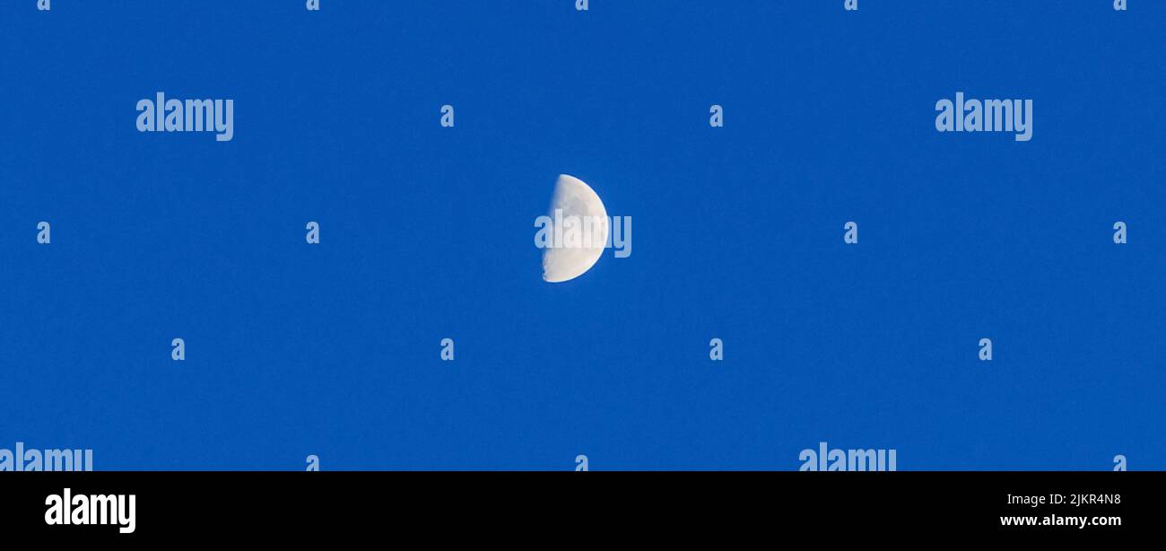 Small moon over blue glowing sky background.The Moon illuminated by the ...