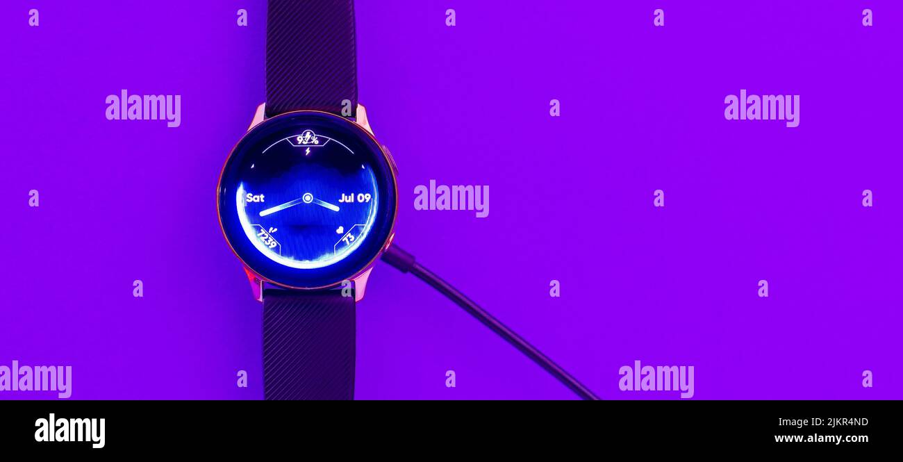 Smart watch on wireless charging with on-screen.Purple,veri peri neon ...