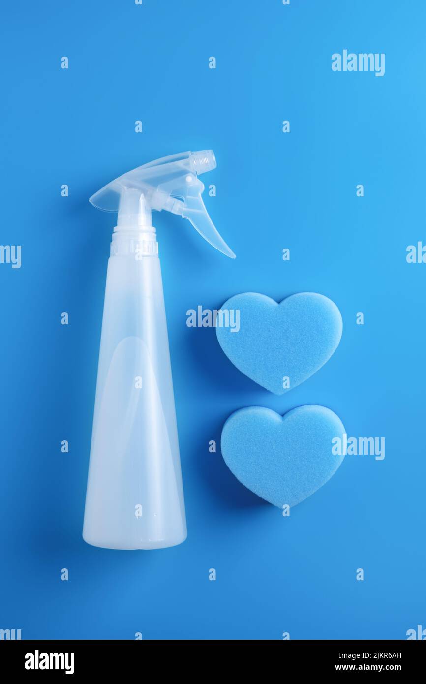 White spray bottle with antibacterial liquid and blue sponges on blue ...
