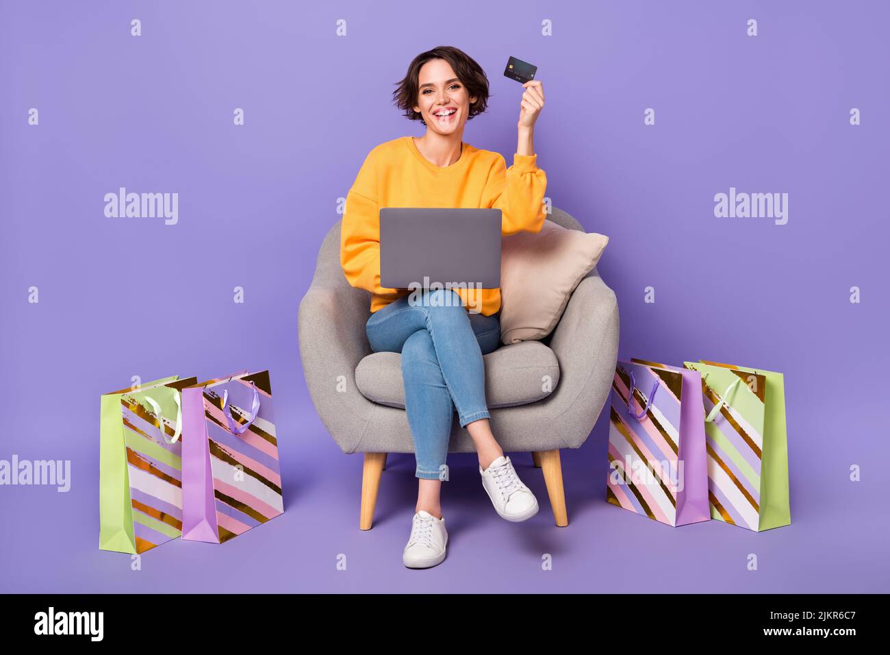 Full body portrait of pretty cheerful girl sit chair use netbook show ...