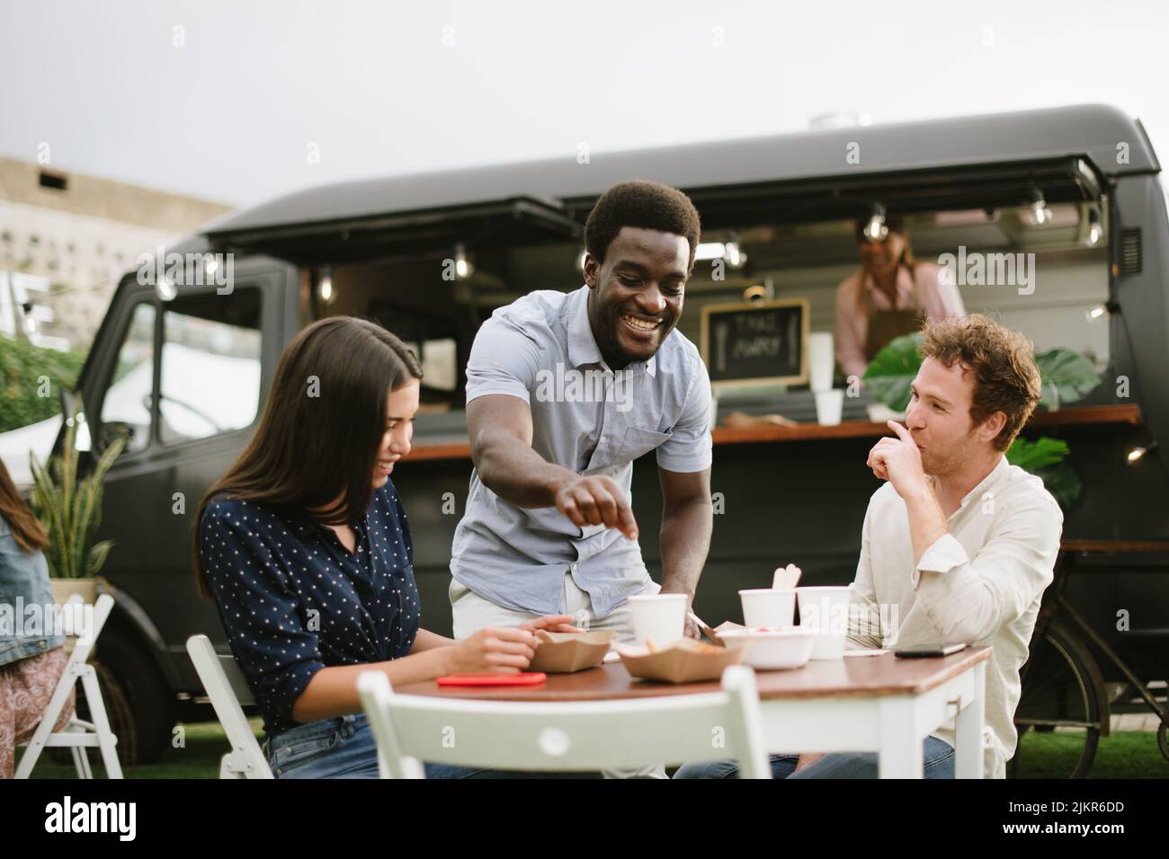Black man stealing food from friends Stock Photo - Alamy