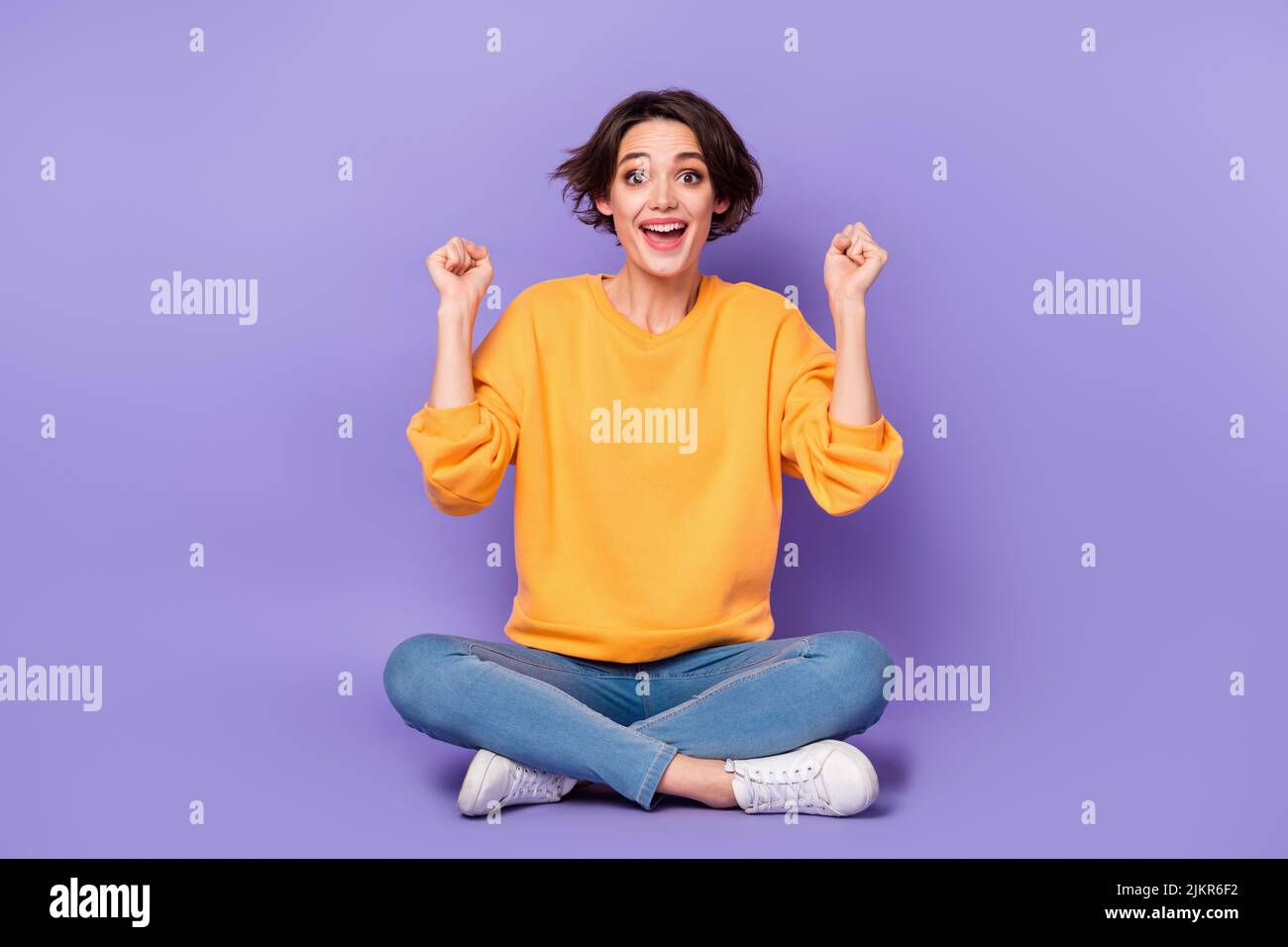 Portrait of attractive cheerful lucky girl sitting lotus pose having ...