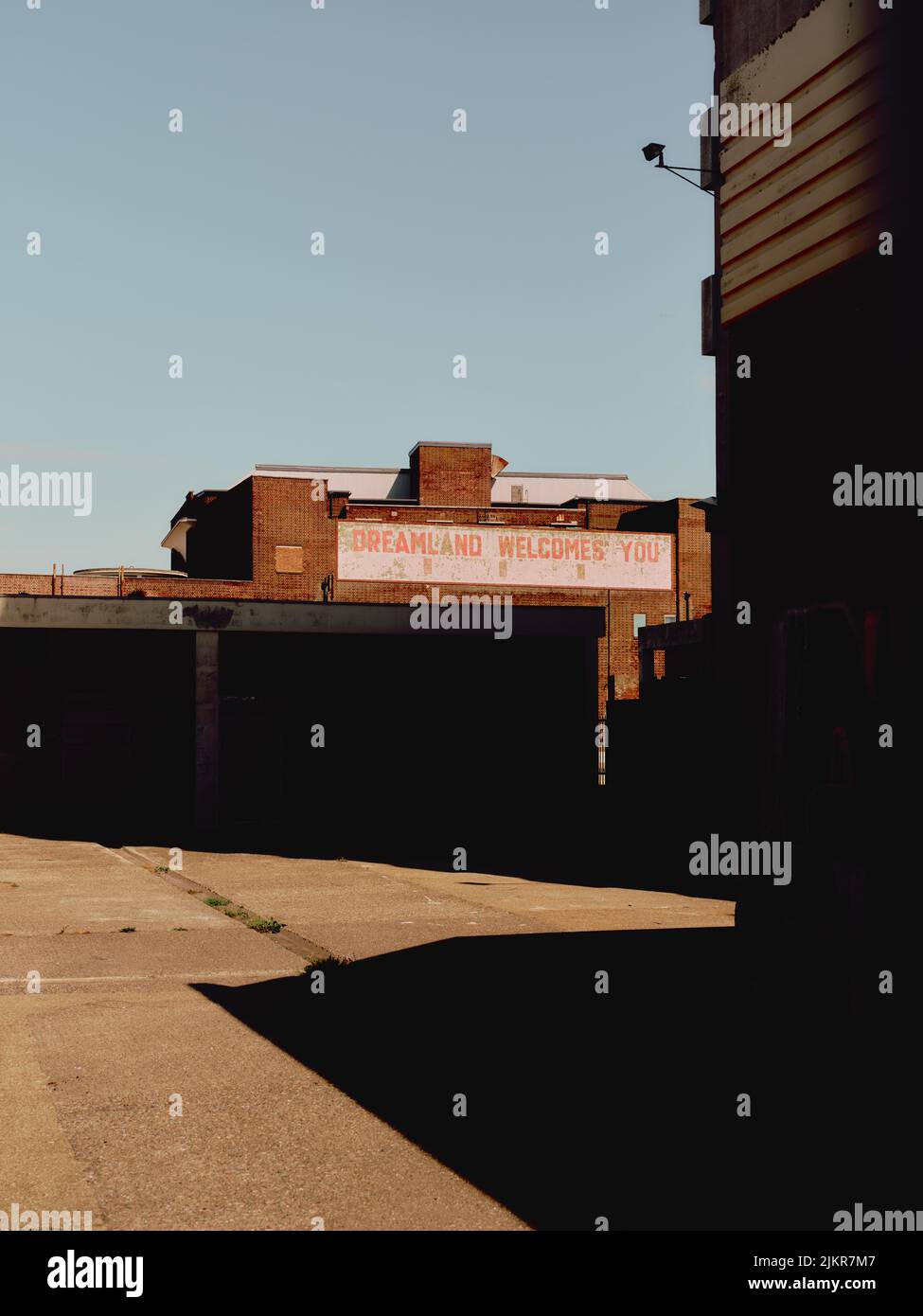 Dreamland Welcomes You - a run down urban concrete empty backyard with ...