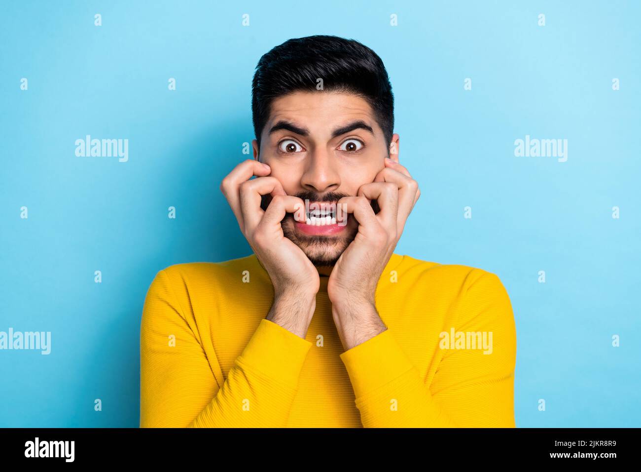 Photo of shocked scared man wear yellow sweater biting fingers isolated ...