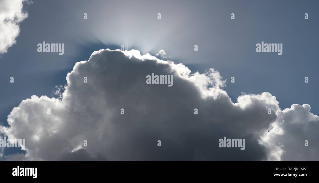 large grey heavy cloud with rim light of sun behind it Stock Photo - Alamy