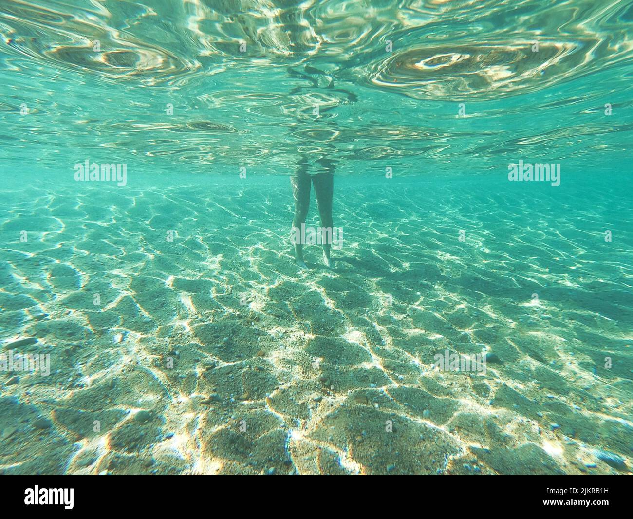 Girl standing on transparent water with turquoise color in Spanish ...