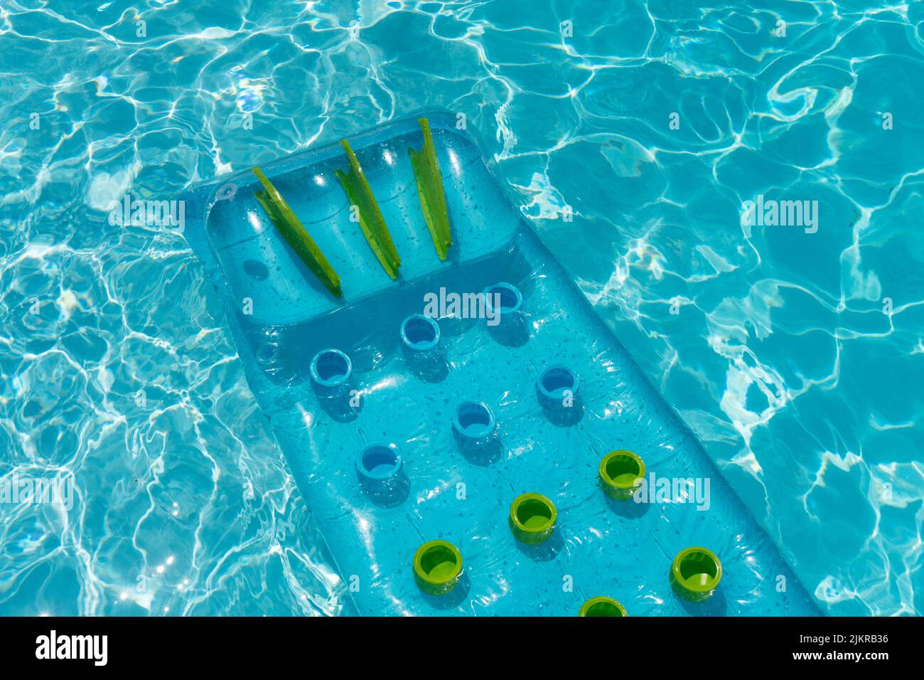 Clear blue summer pool lounger float on a rippled swimming pool Stock ...