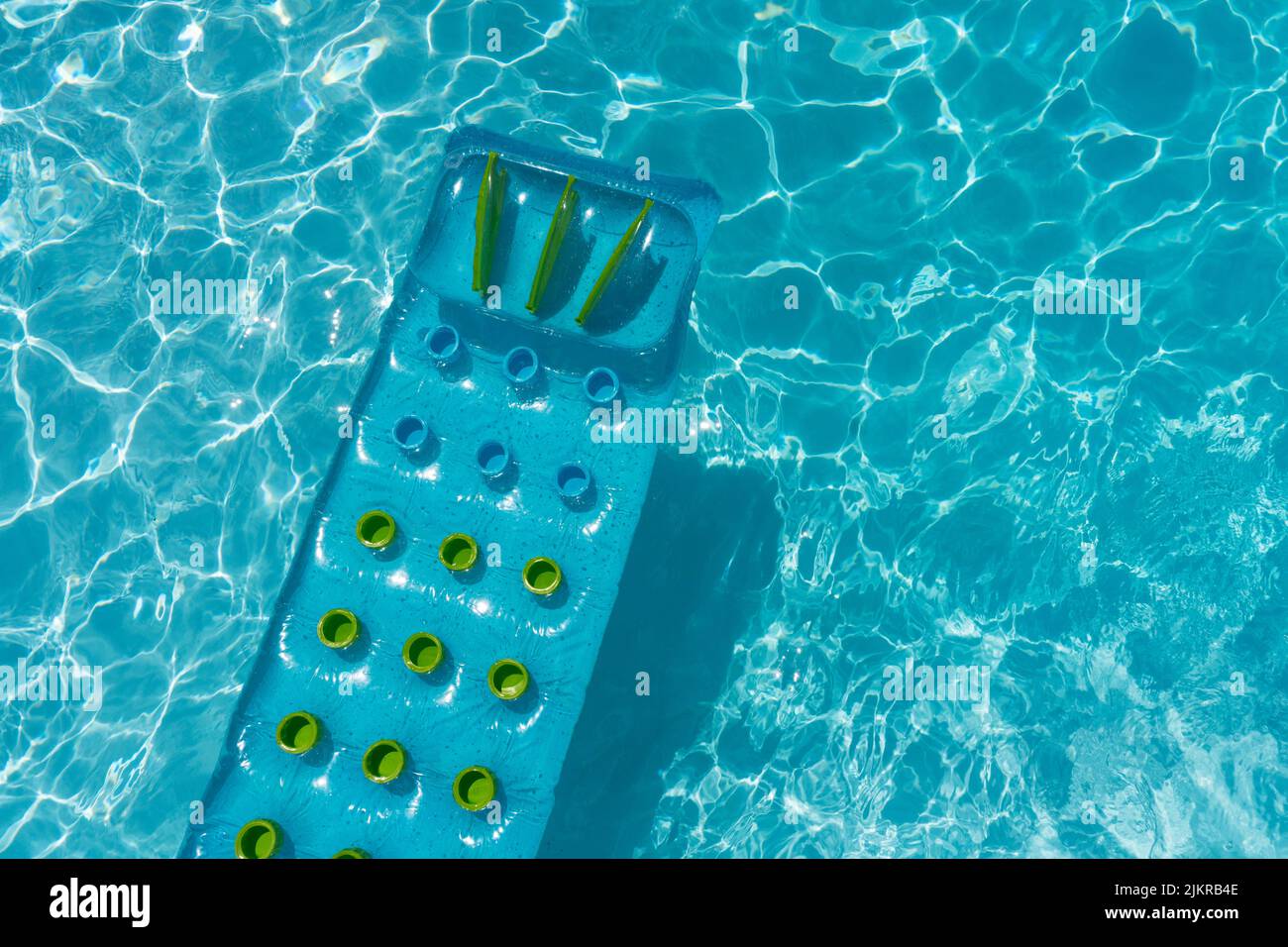 Clear blue summer pool lounger float on a rippled swimming pool Stock ...