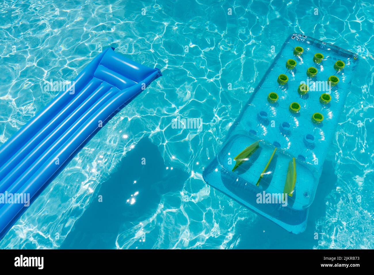 Clear blue summer pool lounger float on a rippled swimming pool Stock ...