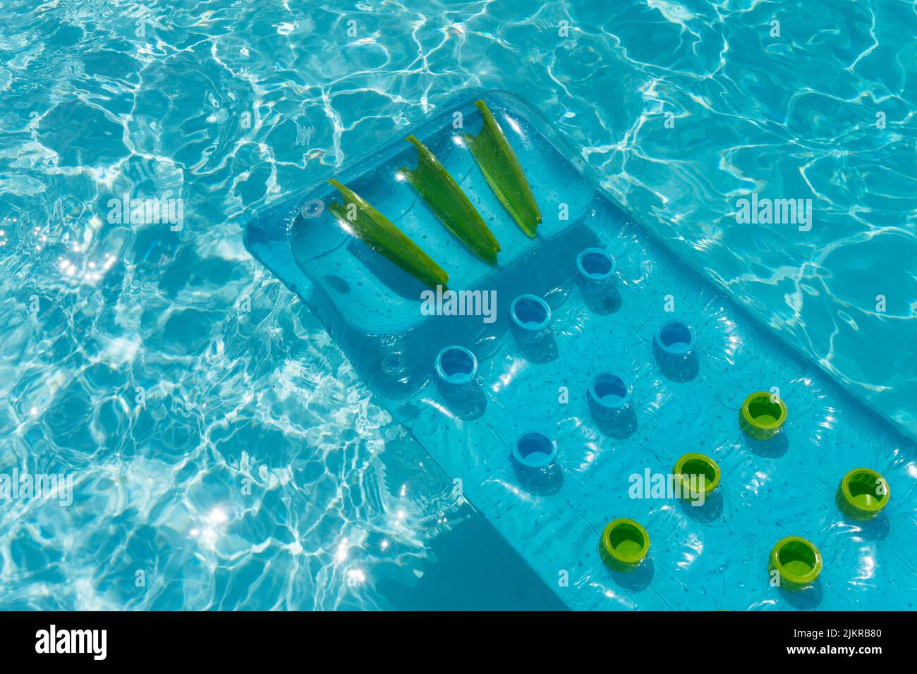 Clear blue summer pool lounger float on a rippled swimming pool Stock ...