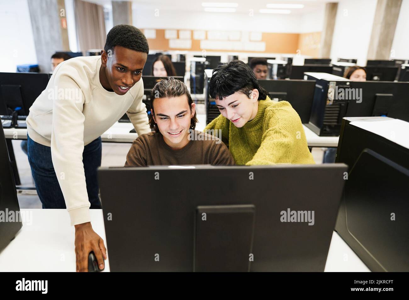 Young multiracial students using computers during business class at school - Focus on african ...