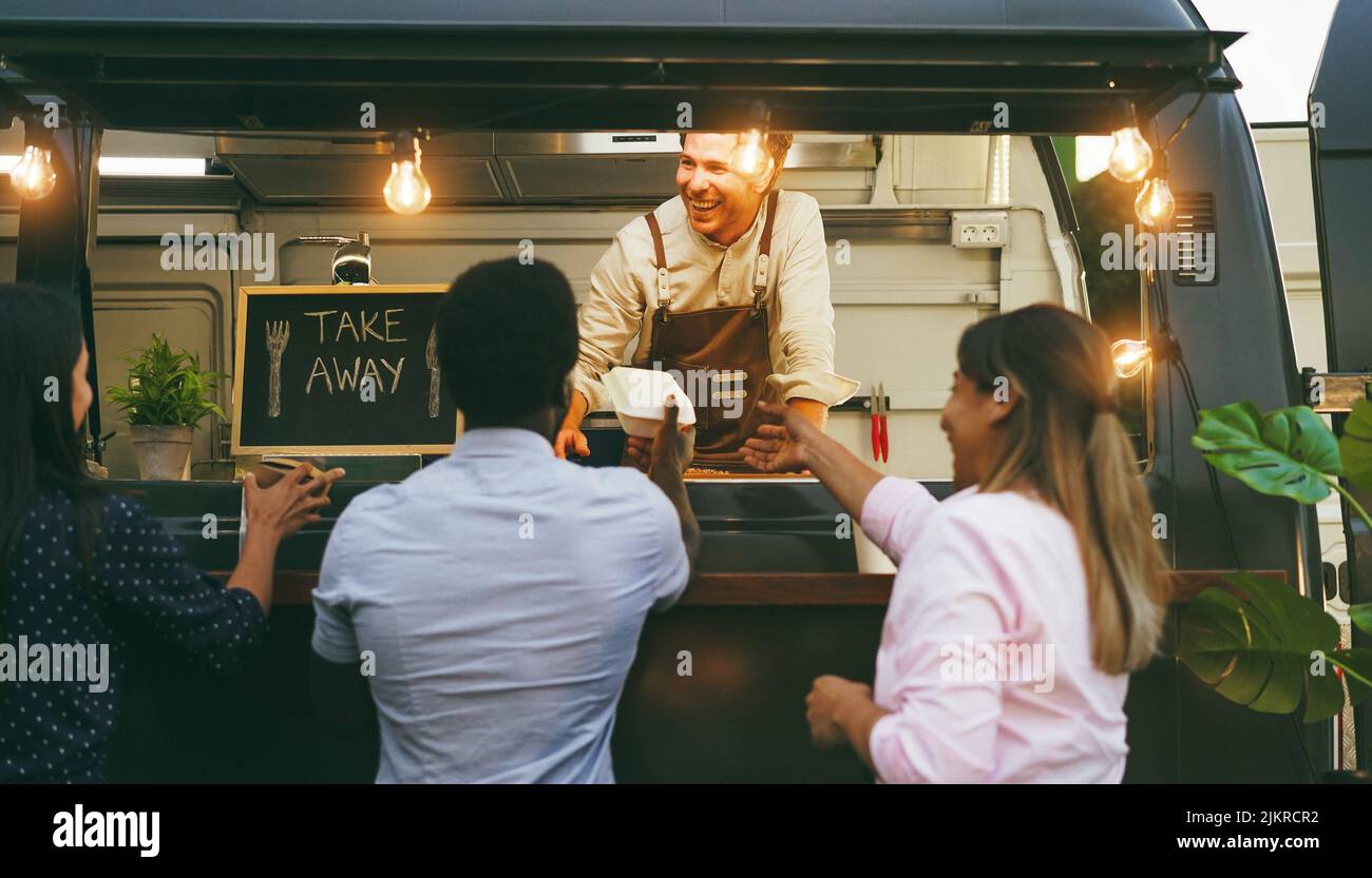 Multiracial people ordering food at counter in food truck outdoor ...