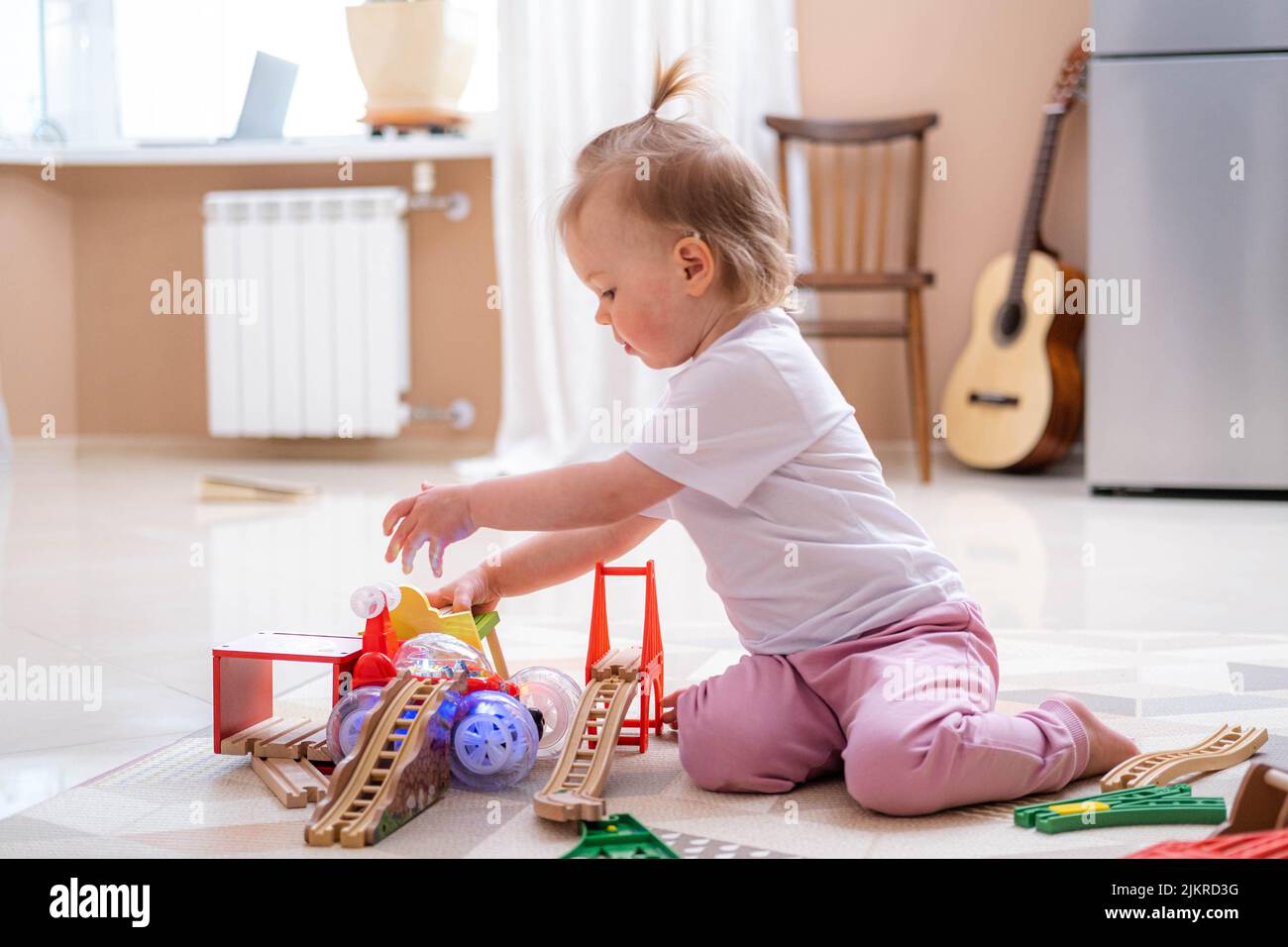 Little baby girl playing color wooden toys at home sitting on floor ...