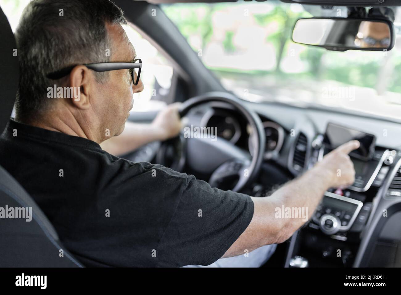 Senior behind the steering wheel using navigation and looking for ...