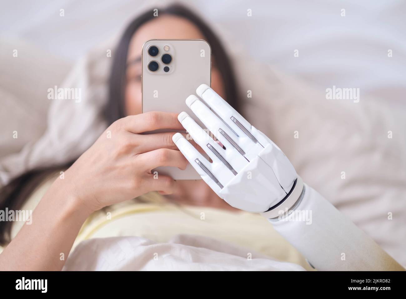 Girl with bionic arm using phone, reading social media and chatting in ...
