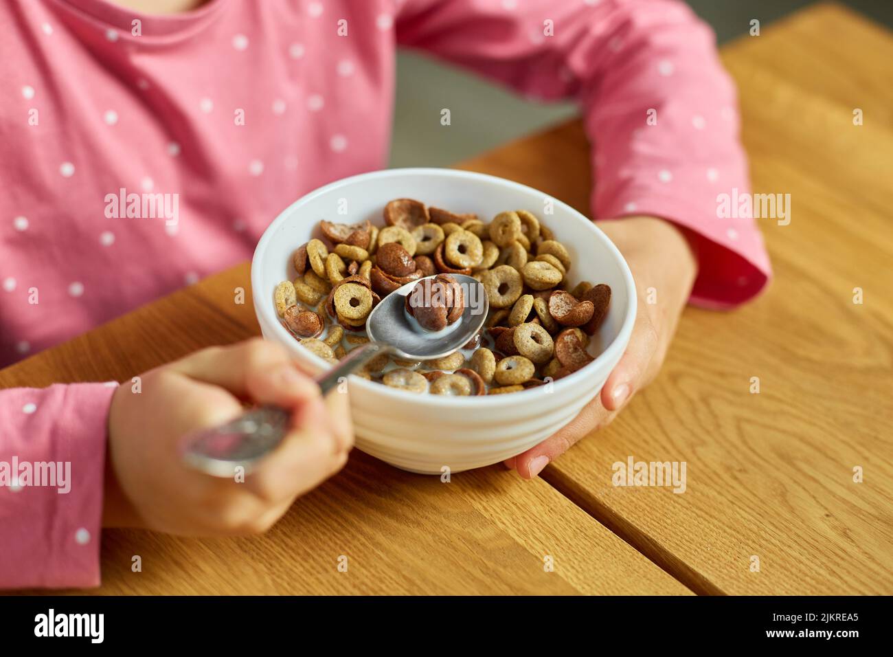Close up Cute little girl enjoy eating cereal with milk for morning ...