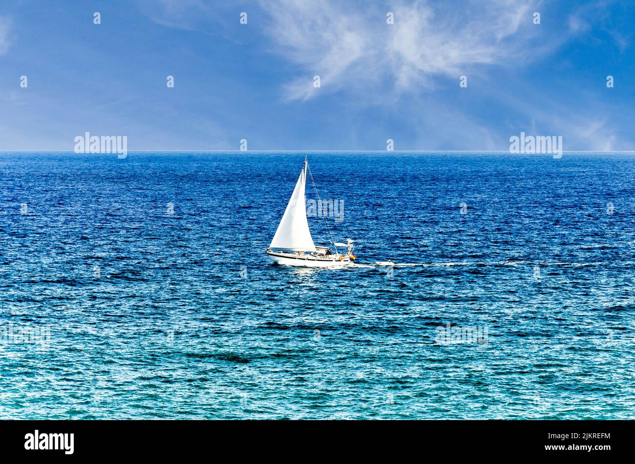 Scene of a small boat with sail in the middle of the blue ocean Stock ...