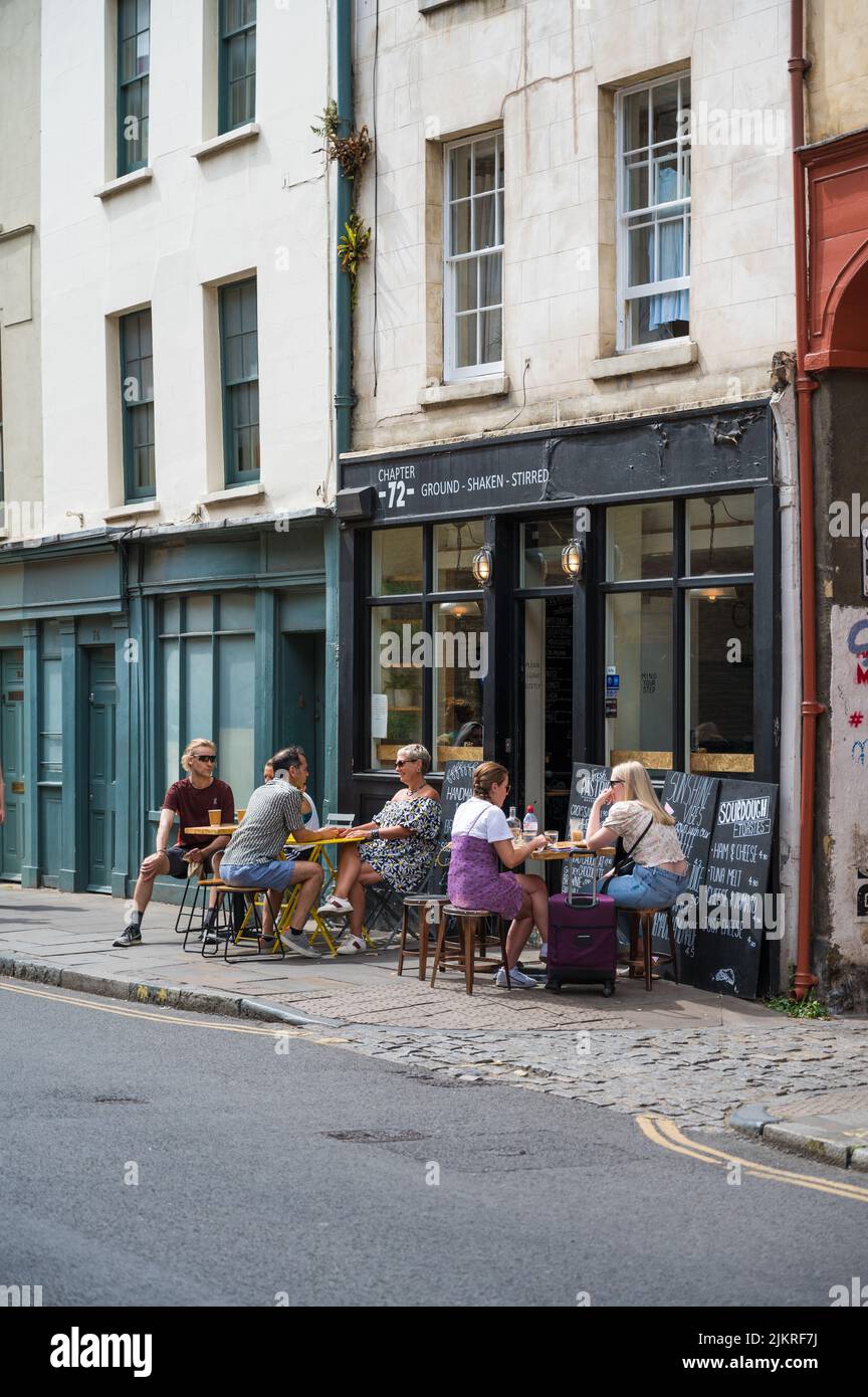 People socialising and enjoying refreshments seated at pavement tables ...