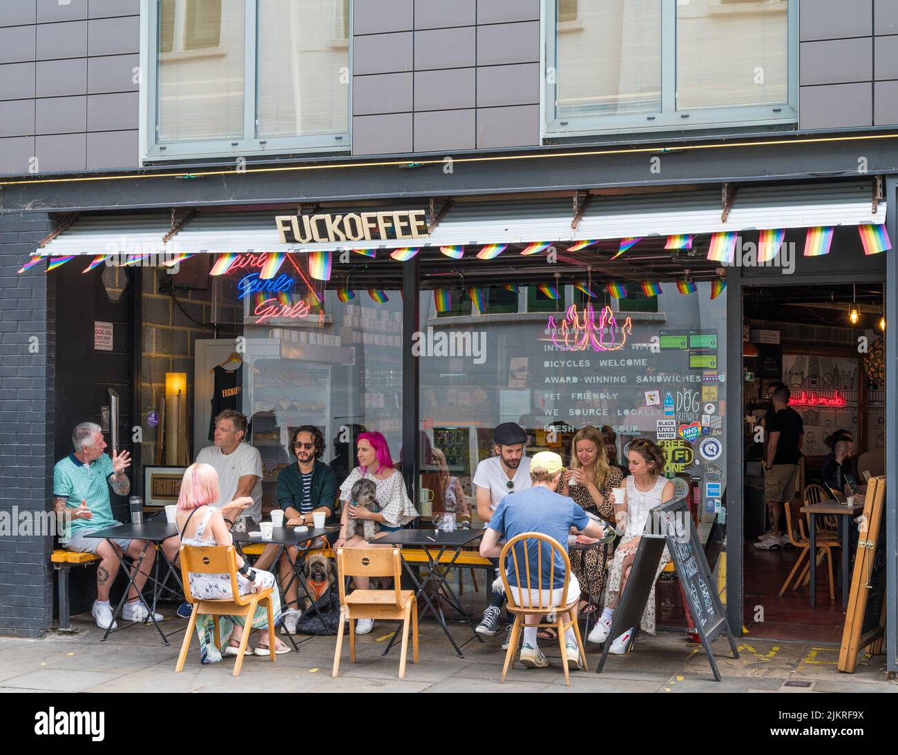 People seated at pavement tables, socialising and enjoying refreshments ...