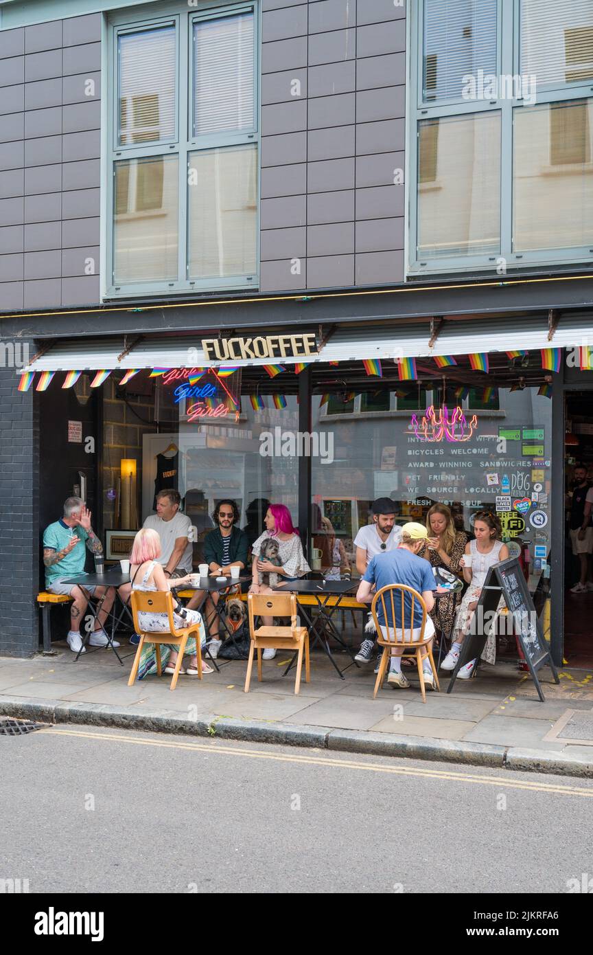 People seated at pavement tables, socialising and enjoying refreshments ...