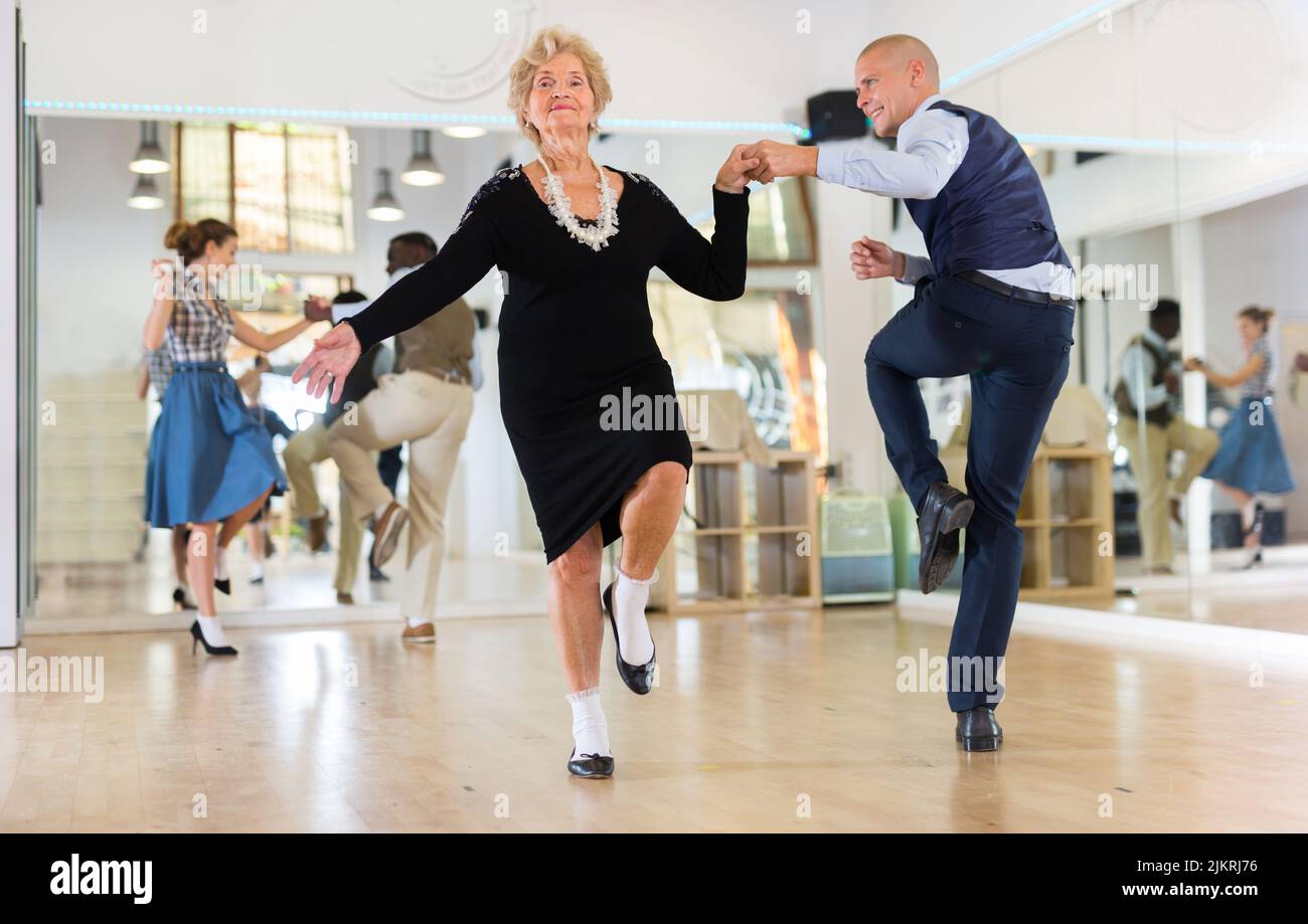 Mature woman dancing swing with young man Stock Photo - Alamy