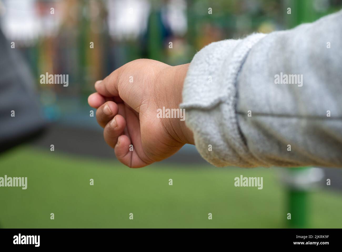 Close up of young child's outstretched hand reaching for something or ...
