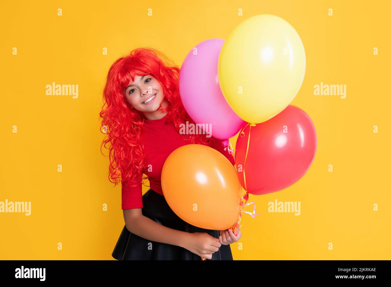 glad kid with party balloon on yellow background Stock Photo - Alamy