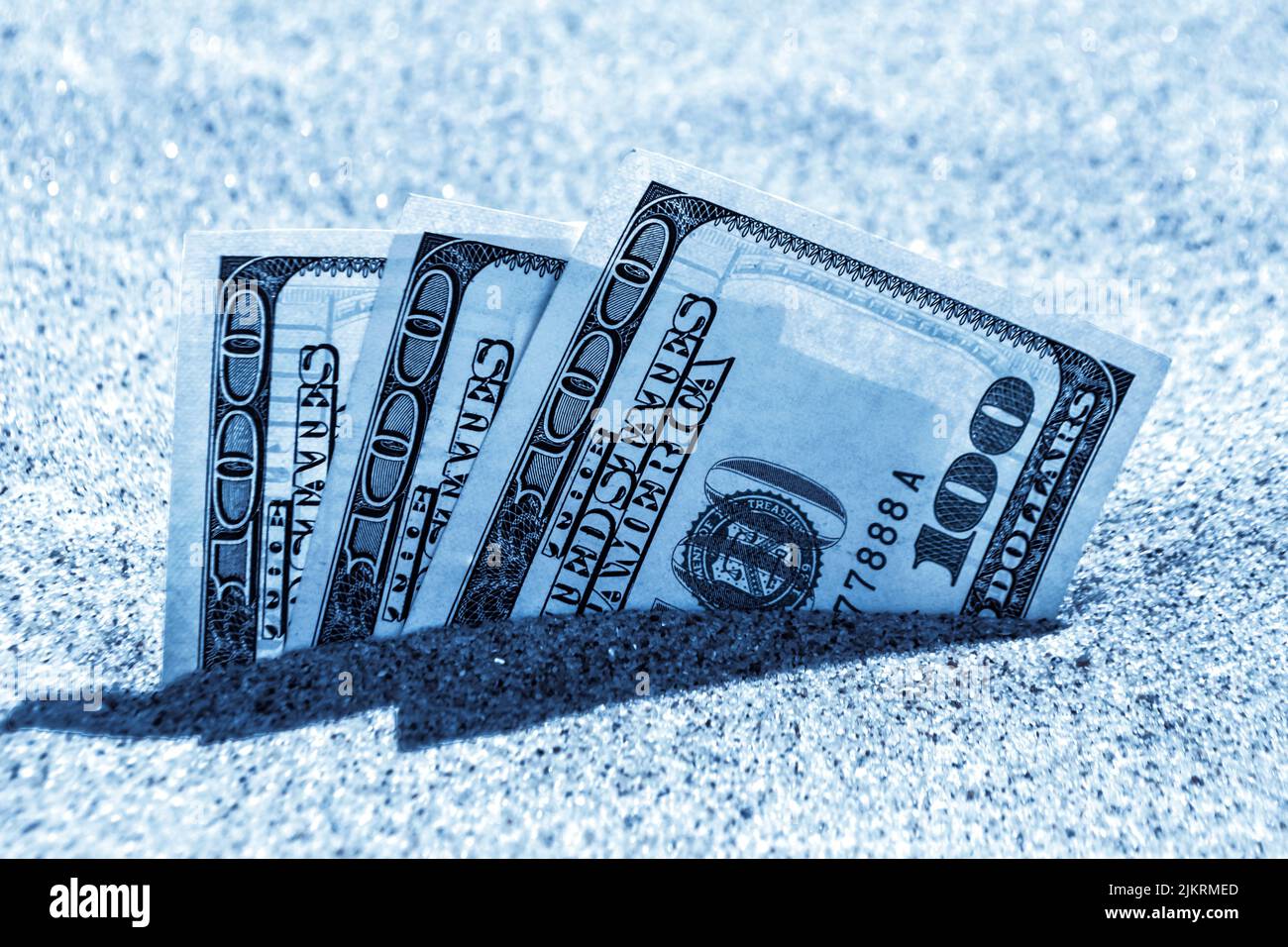 Money dolars half covered with sand lie on beach close-up. Money grows ...