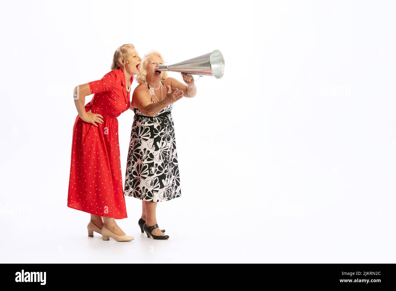 Two charming senior women in retro vintage dresses posing isolated on ...