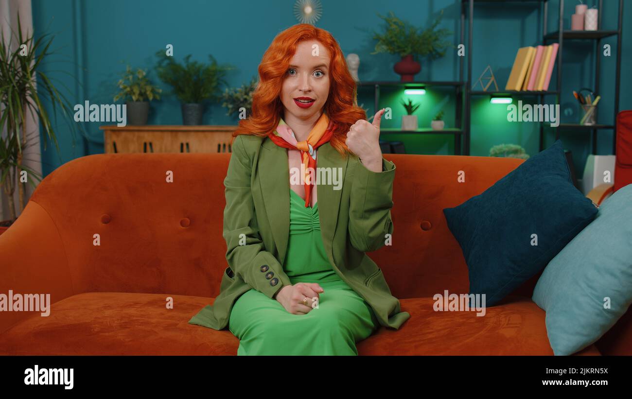 Great job. Redhead young woman in green dress showing thumbs up and ...