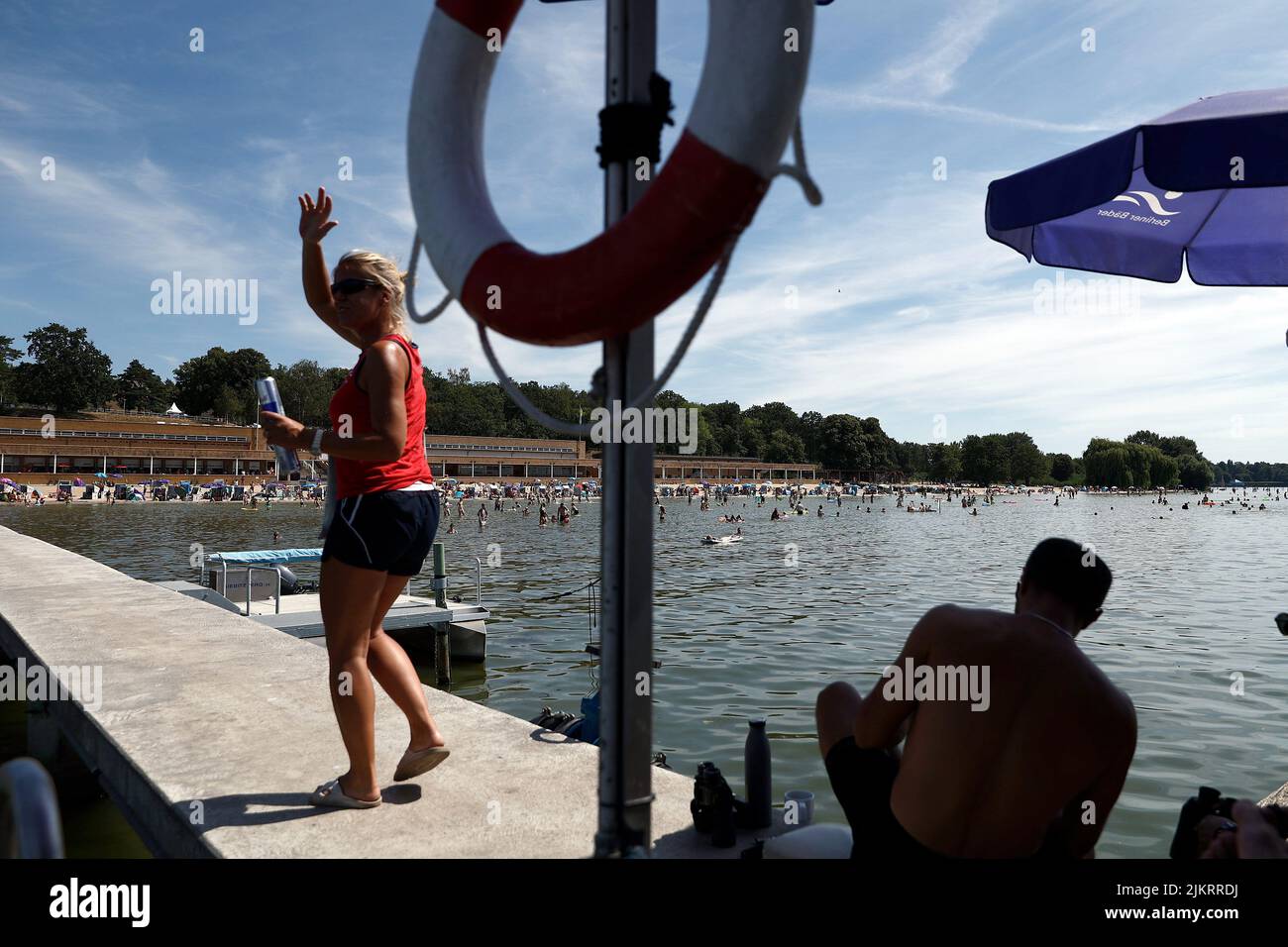 Berlin, Germany. 03rd Aug, 2022. A lifeguard waves on a jetty after her ...