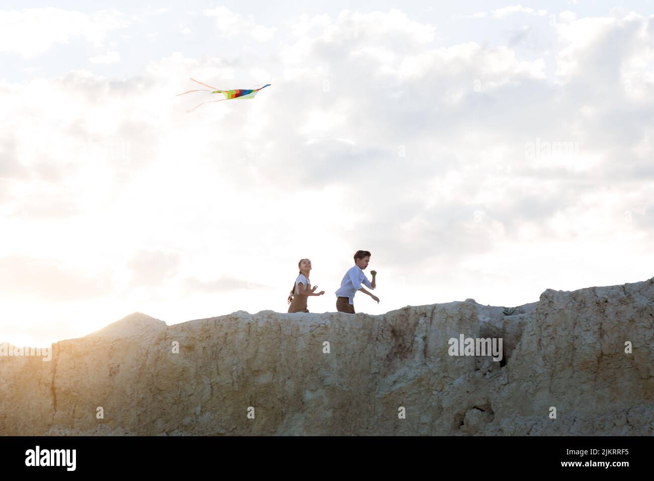 Children run with a kite sunset, beautiful silhouettes Stock Photo - Alamy