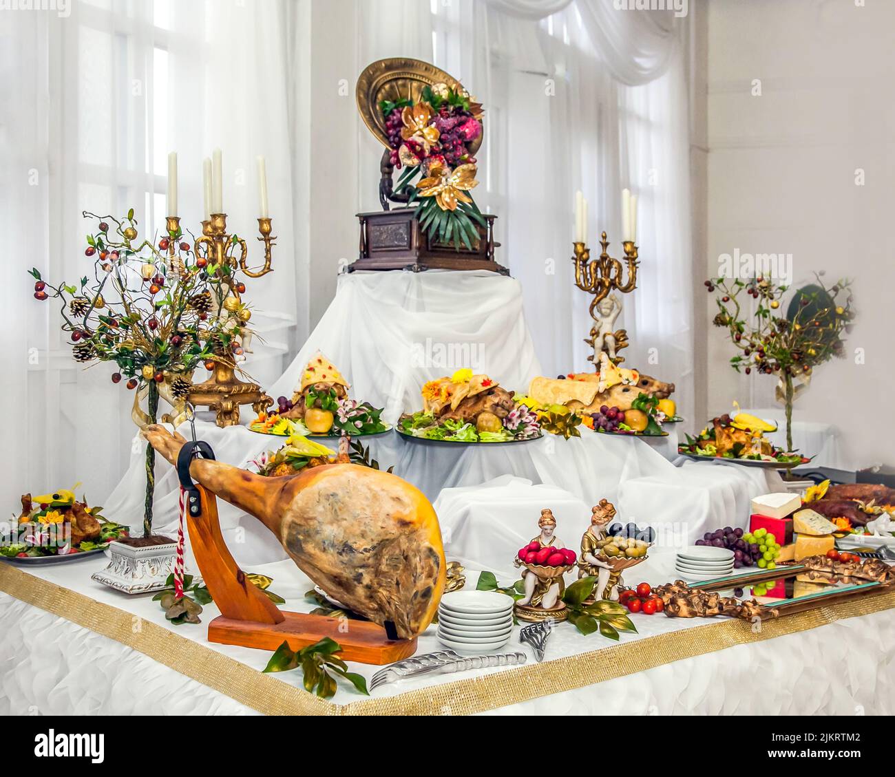 Buffet table with meat snacks, dried pork leg, baked pigs in dough with ...