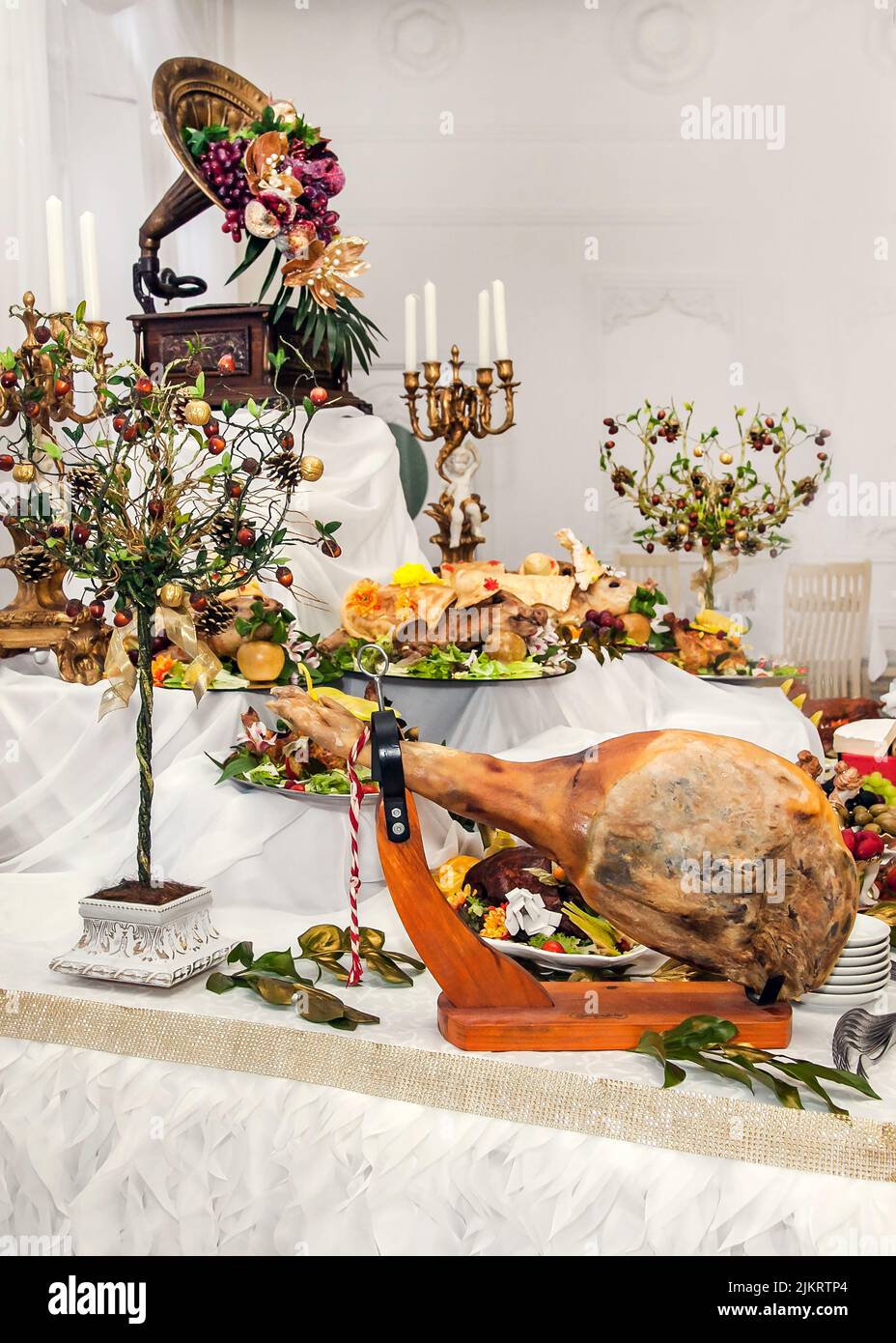 Buffet table with meat snacks, dried pork leg, baked pigs in dough with ...