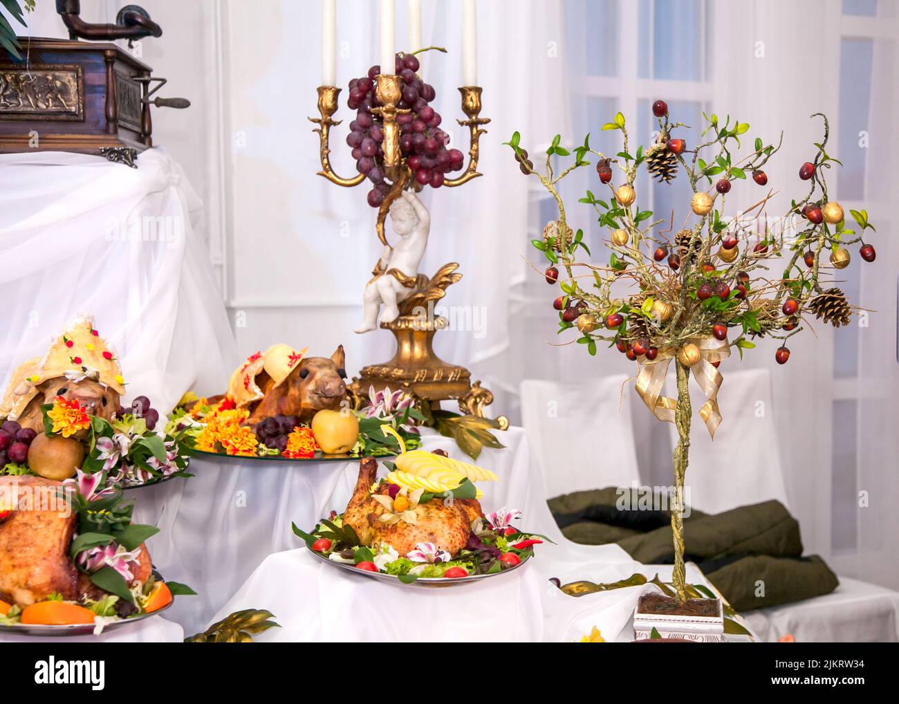 Buffet table with meat snacks, baked pigs in dough, cheese, turkey with ...