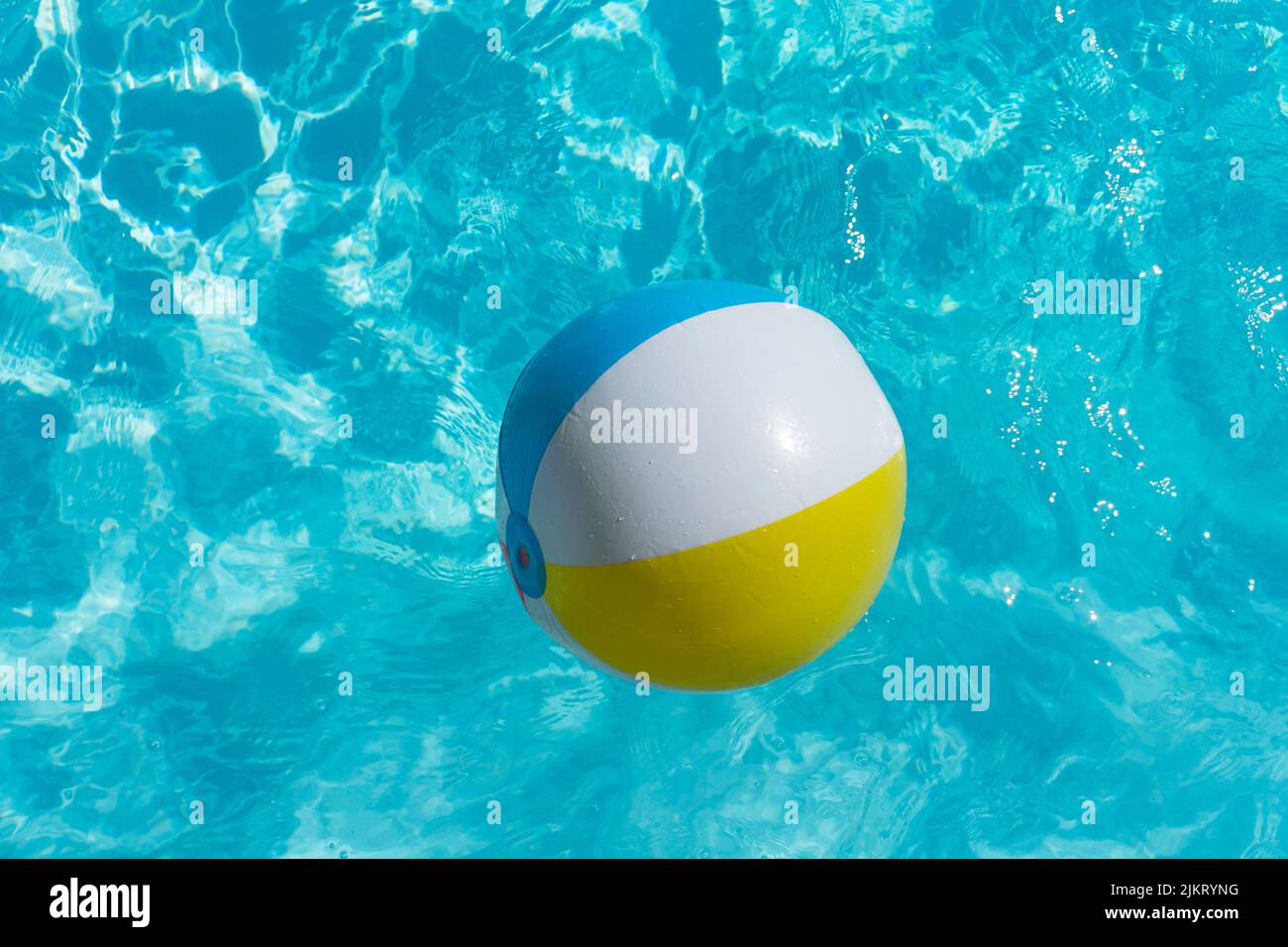 Inflatable beach ball floating on a summer swimming pool Stock Photo ...
