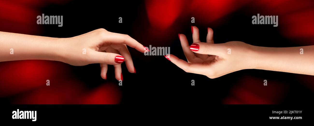 Two female hands with beautiful manicure - red nails on dark black ...