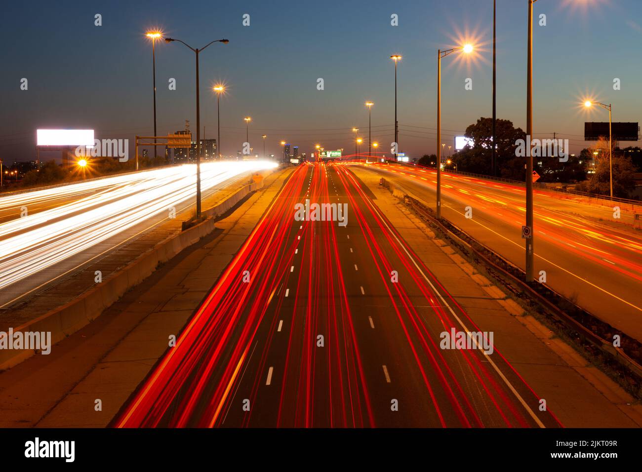 Long exposure shot of busy traffic on a highway under the moon and blue ...